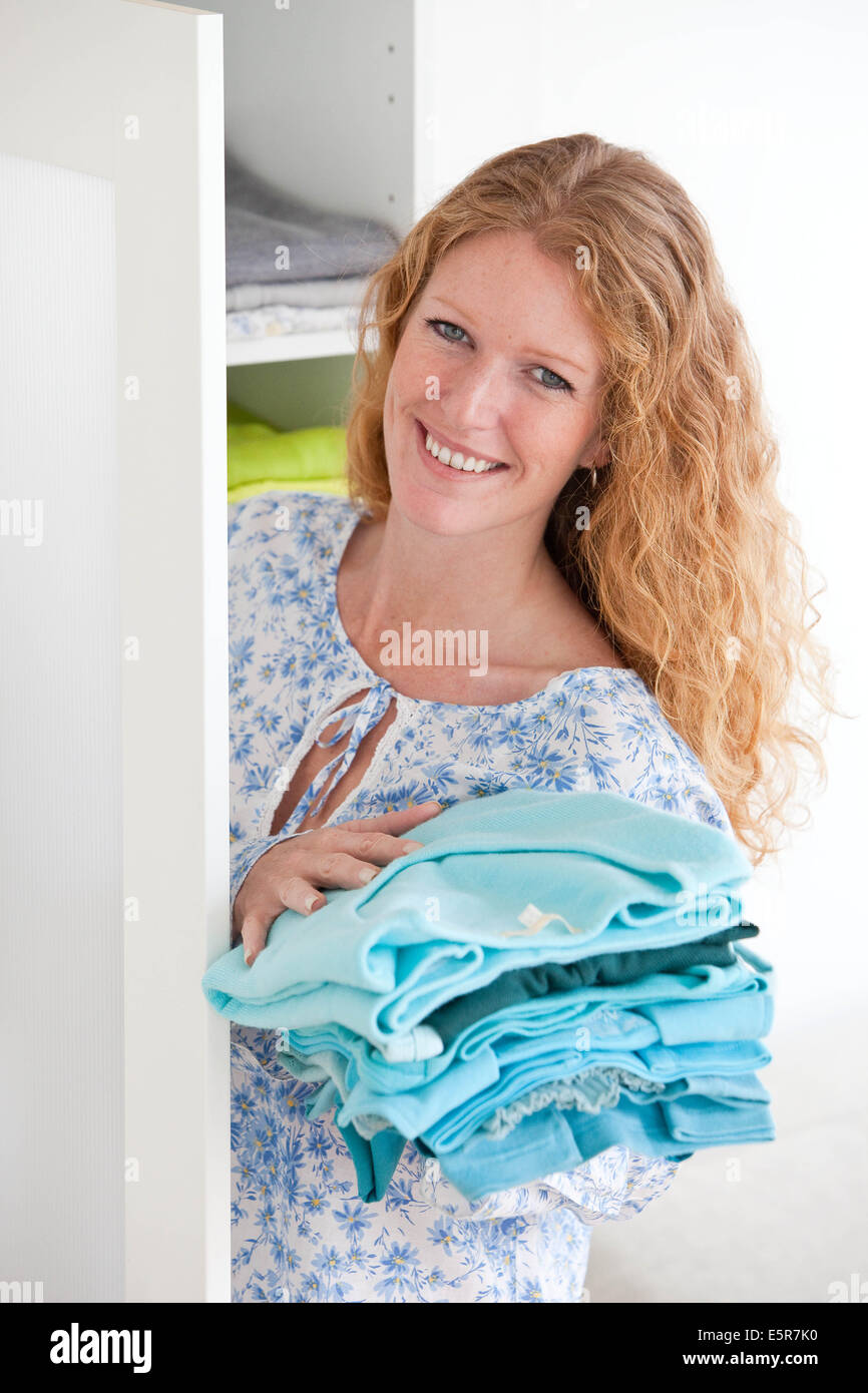 Woman organizing clothes in cupboard Stock Photo - Alamy