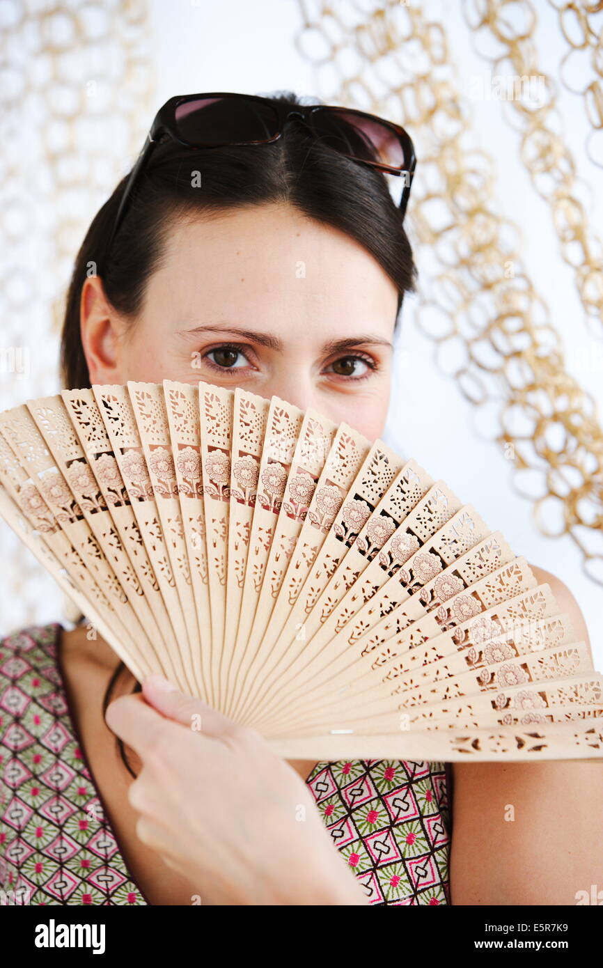 Woman cooling her face with a fan Stock Photo - Alamy
