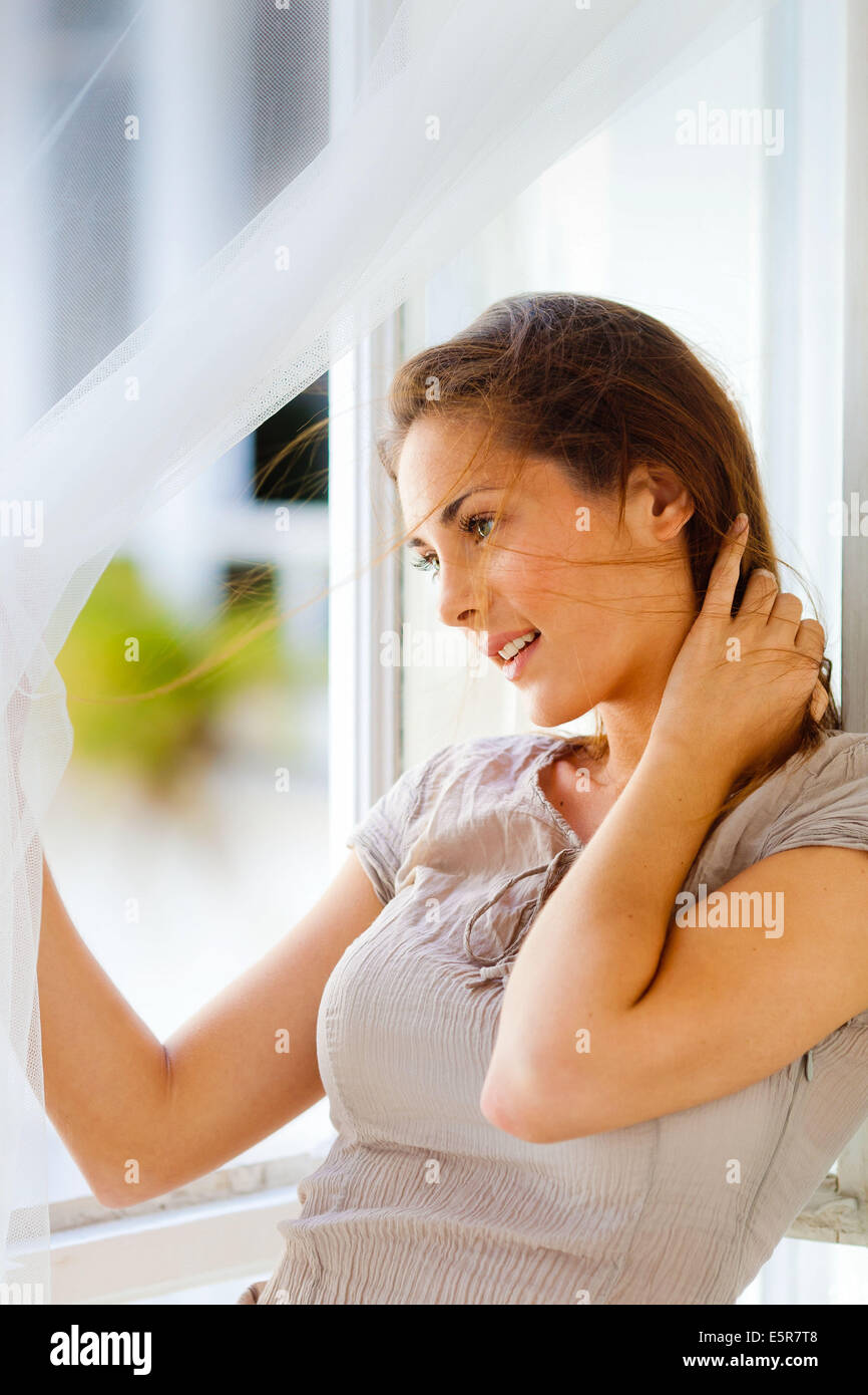 Woman looking out window Stock Photo - Alamy