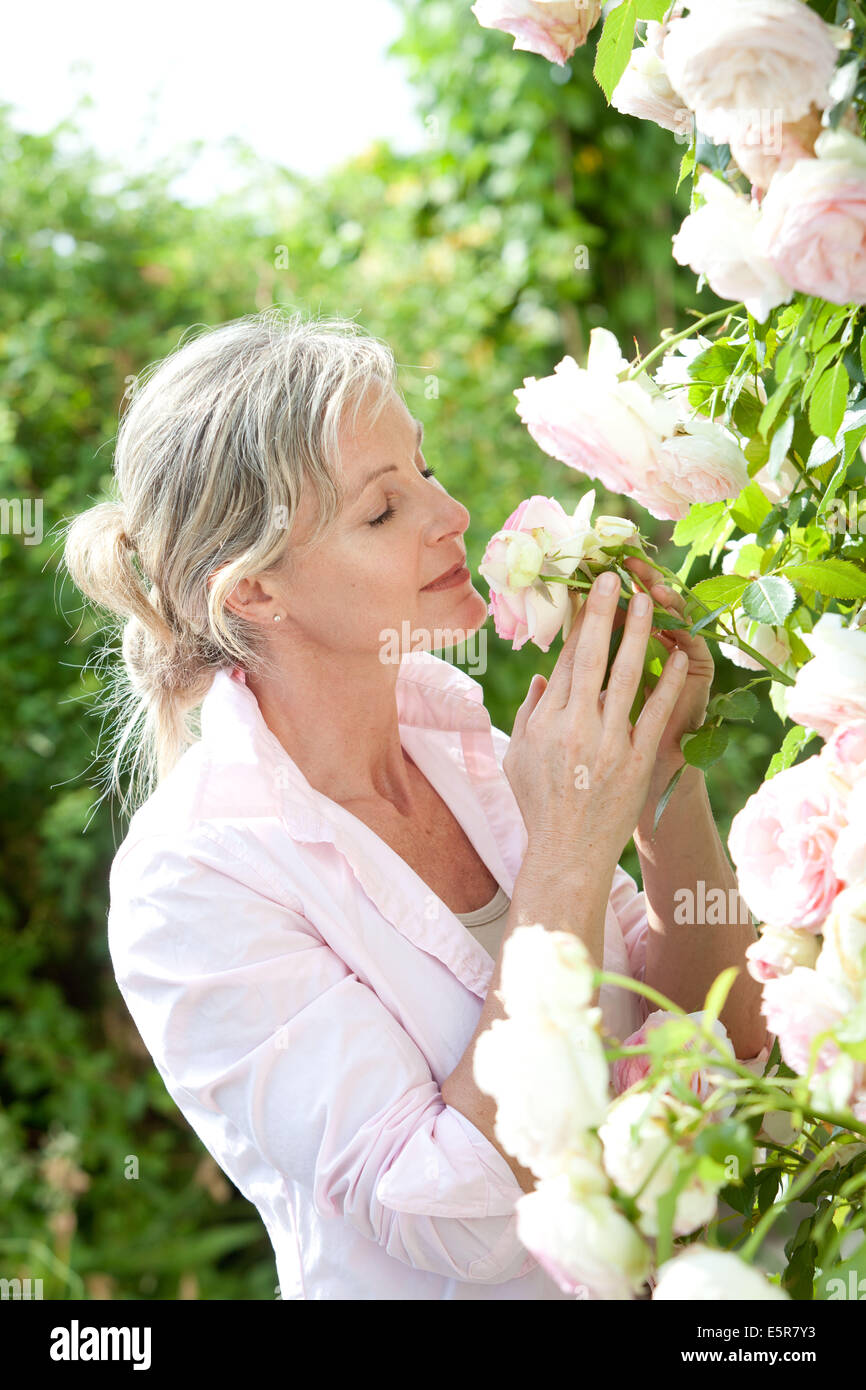 Woman smelling roses Stock Photo - Alamy