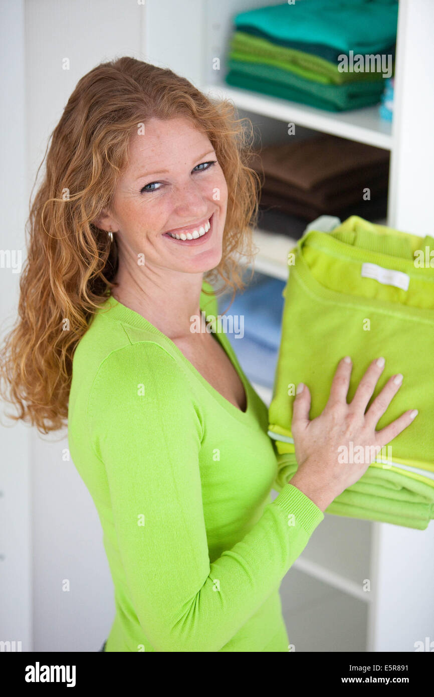 Woman organizing clothes in cupboard Stock Photo - Alamy