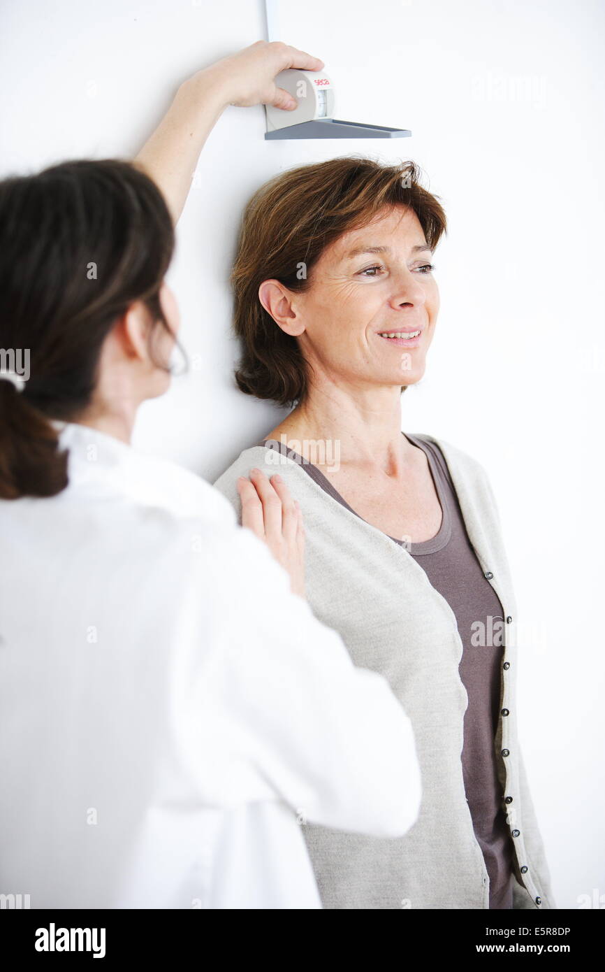 A doctor measuring the height of a patient during medical consultation ...