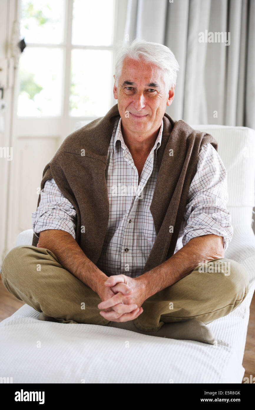Senior man sitting on chair Stock Photo - Alamy