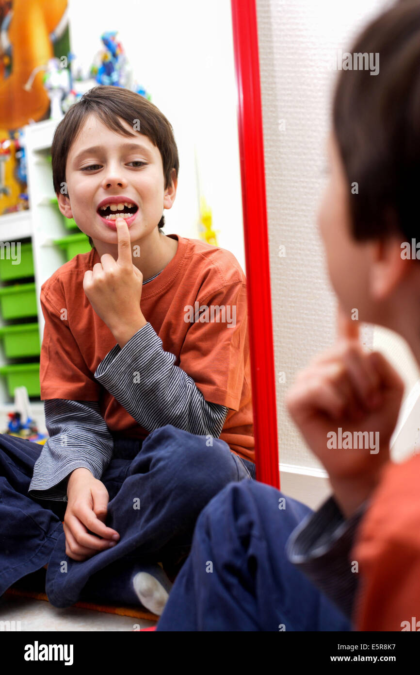 8 year old child checking teeth in mirror Stock Photo - Alamy