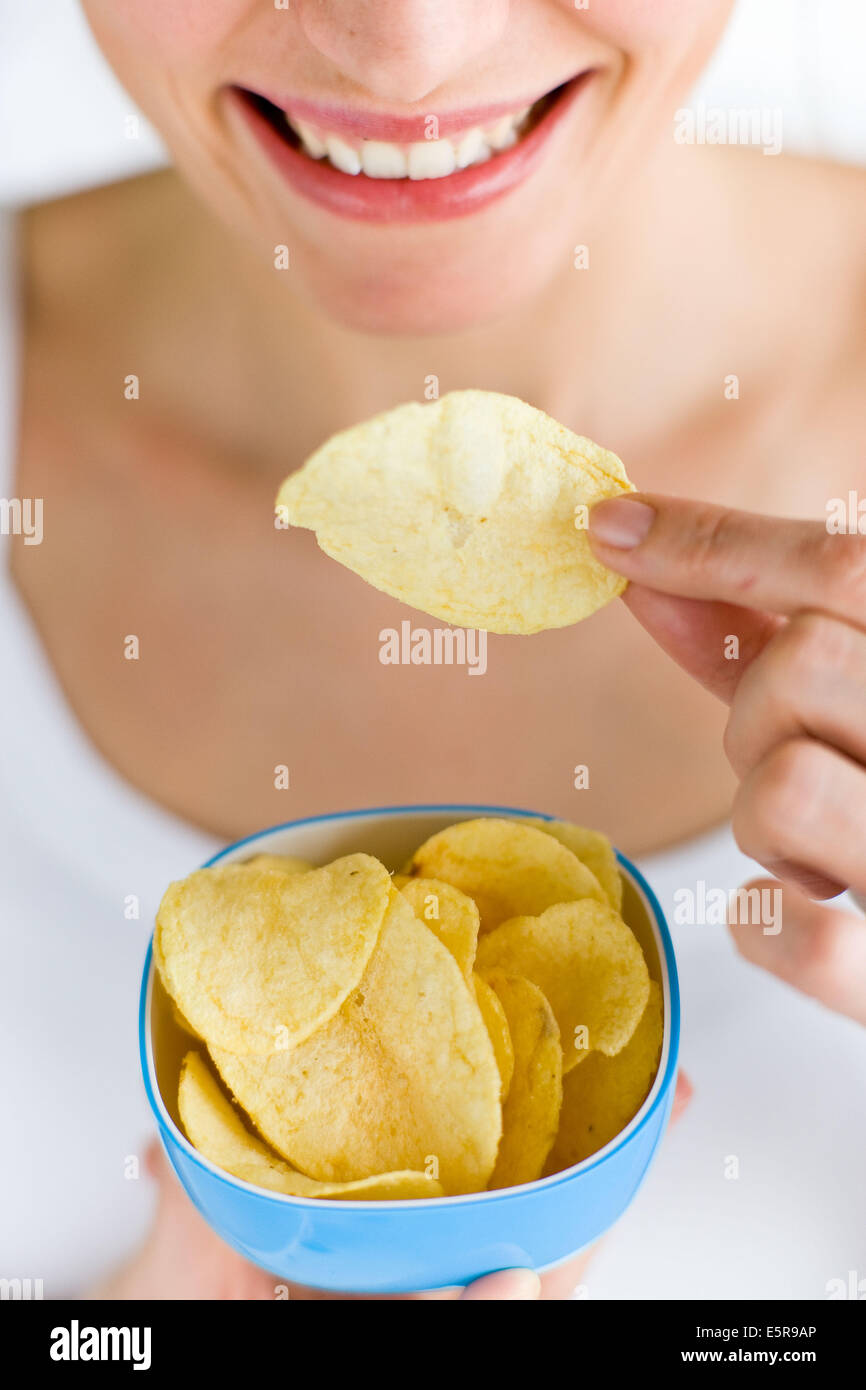 Woman eating potato chips Stock Photo - Alamy