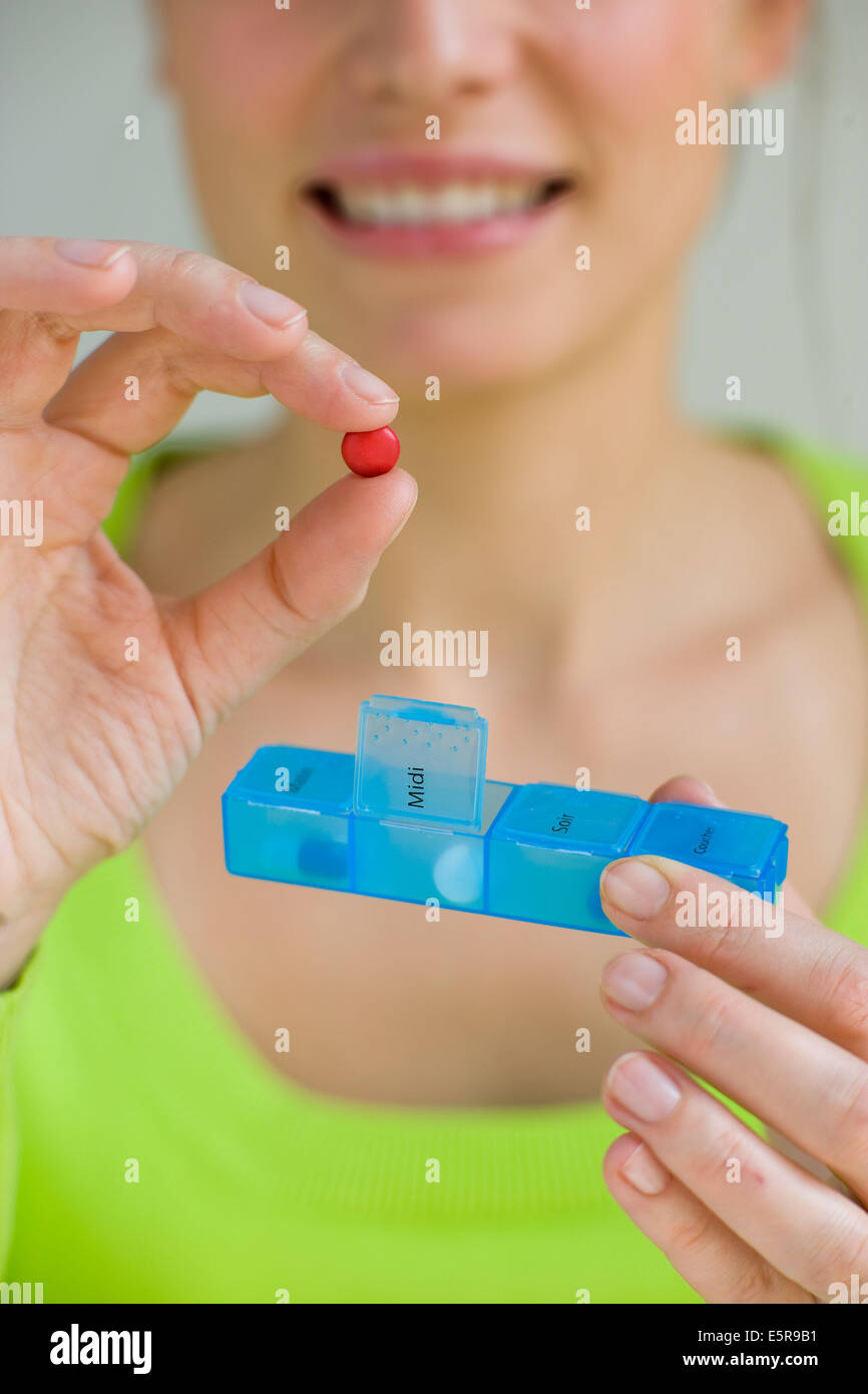 Woman taking medication from pillbox Stock Photo - Alamy