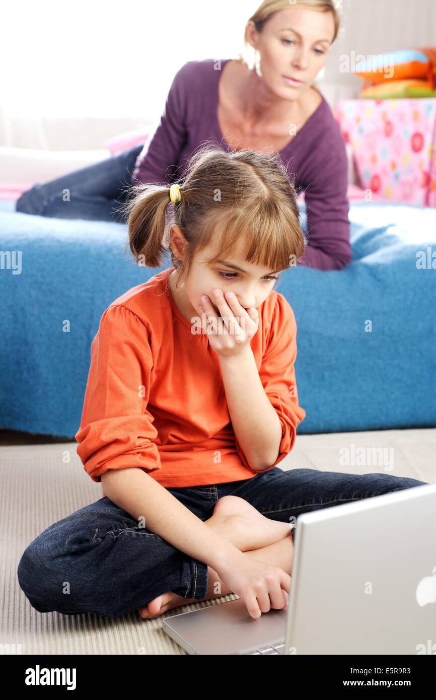 7 year old girl with her mother using laptop computer Stock Photo - Alamy
