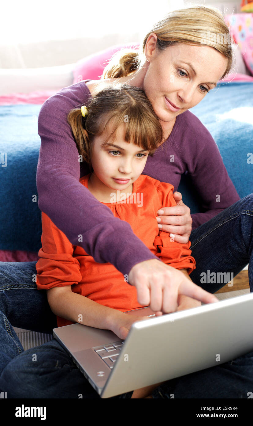 7 year old girl with her mother using laptop computer Stock Photo - Alamy