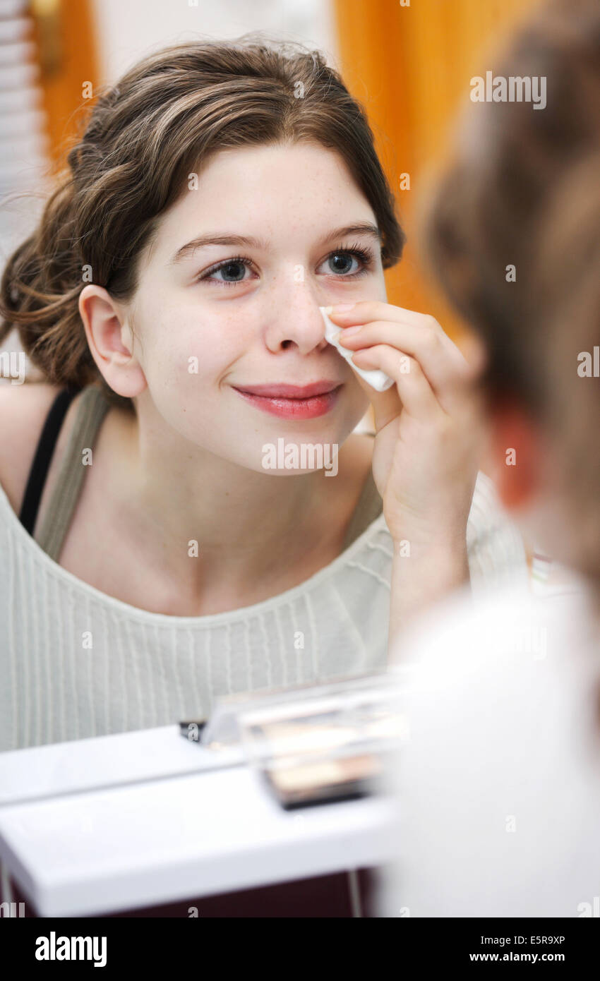 Teenage girl cleaning her face with lotion Stock Photo - Alamy
