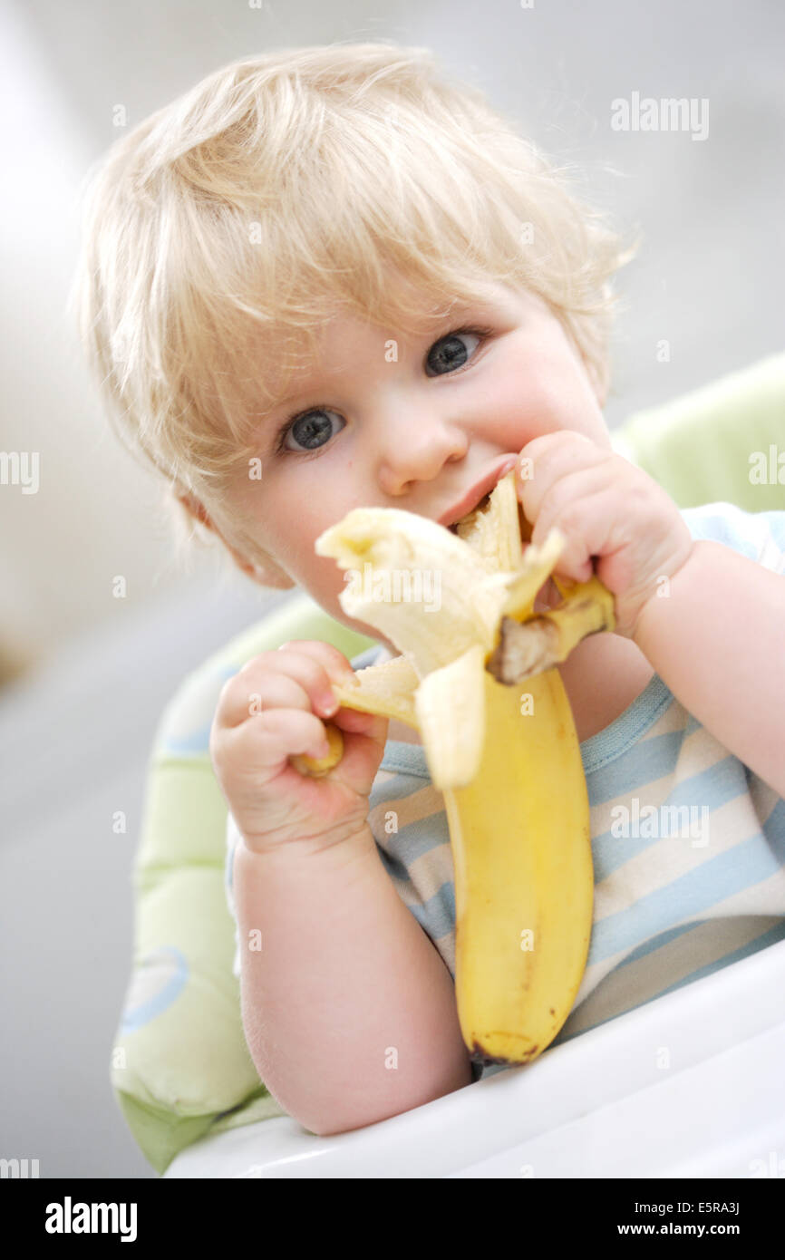 10 month old baby eating a banana Stock Photo - Alamy