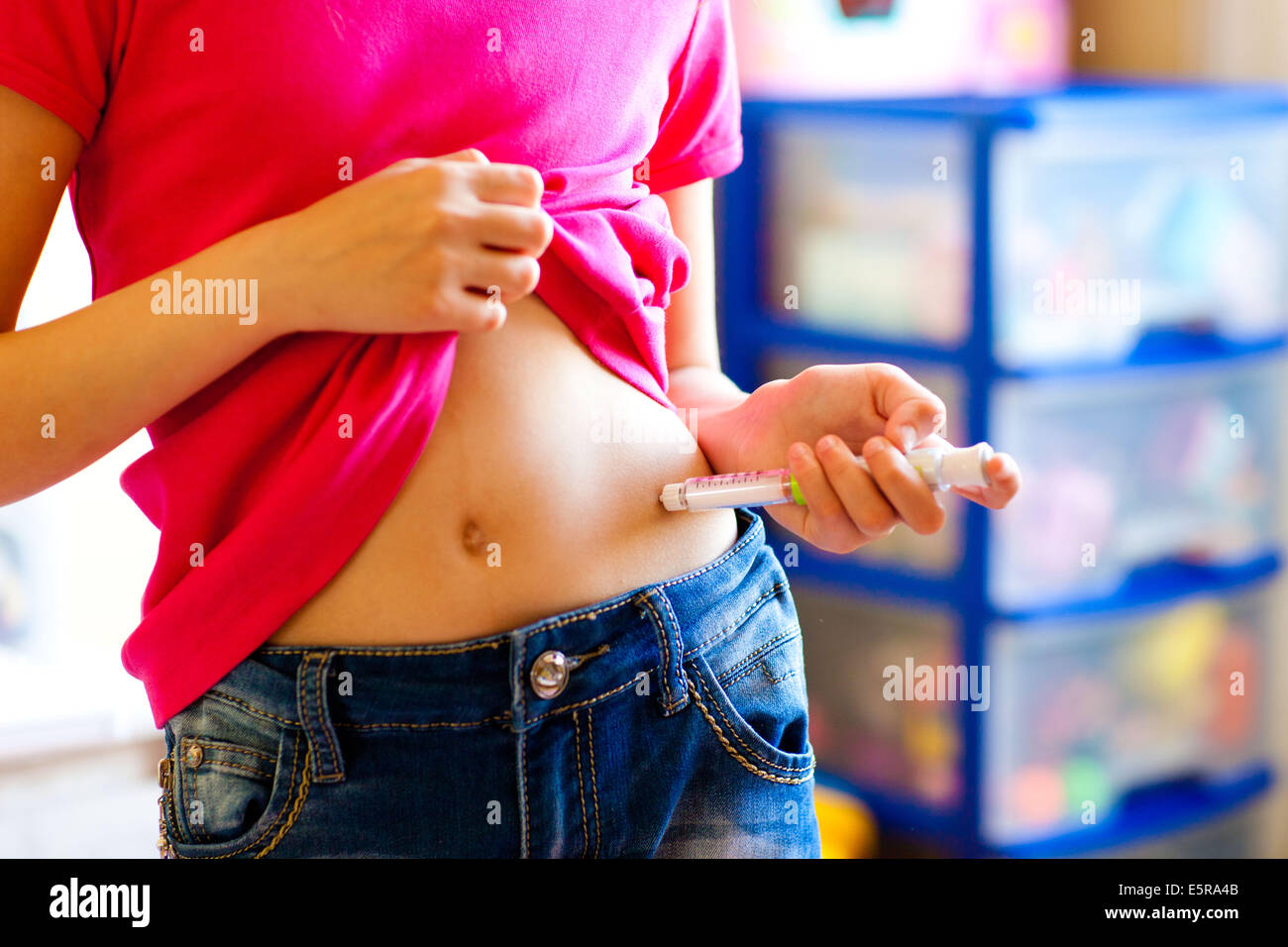 11-year-old girl giving himself an insulin injection with an insulin ...