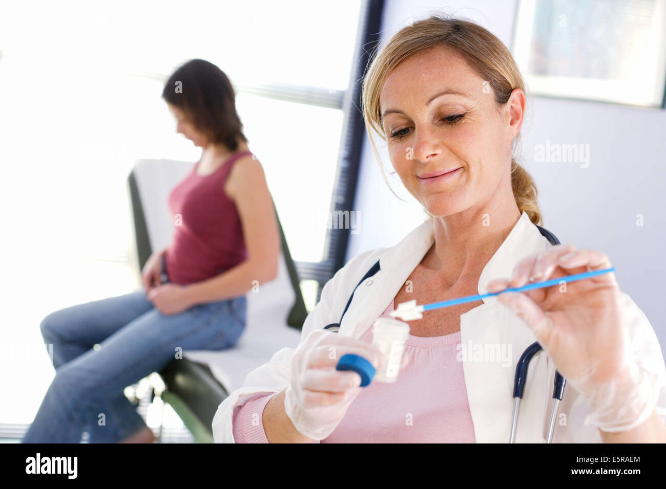 Gynecologist performing a cervical smear or pap test on a teenage ...