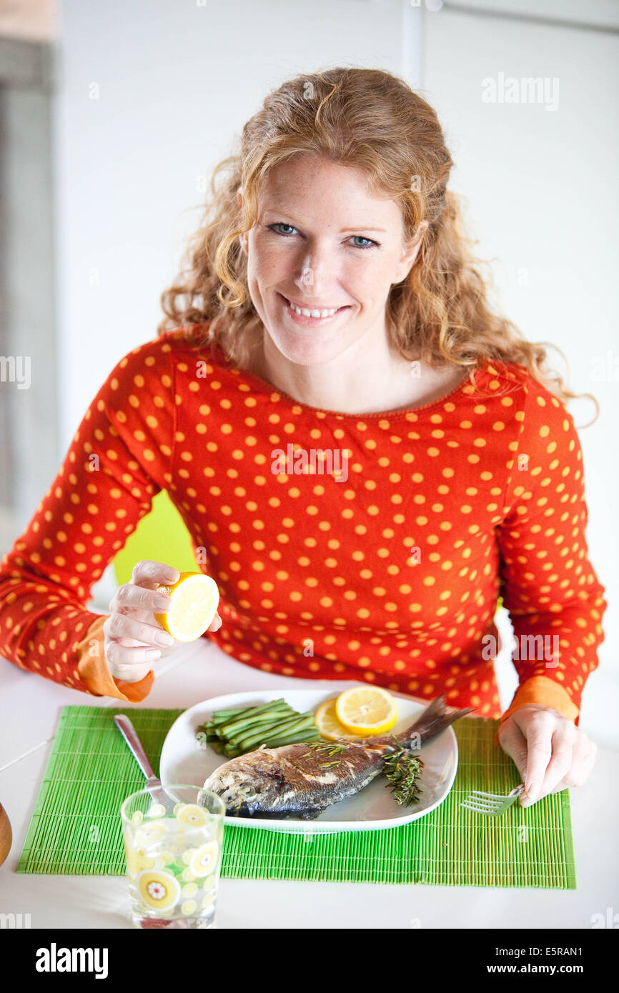 Woman eating fish Stock Photo - Alamy