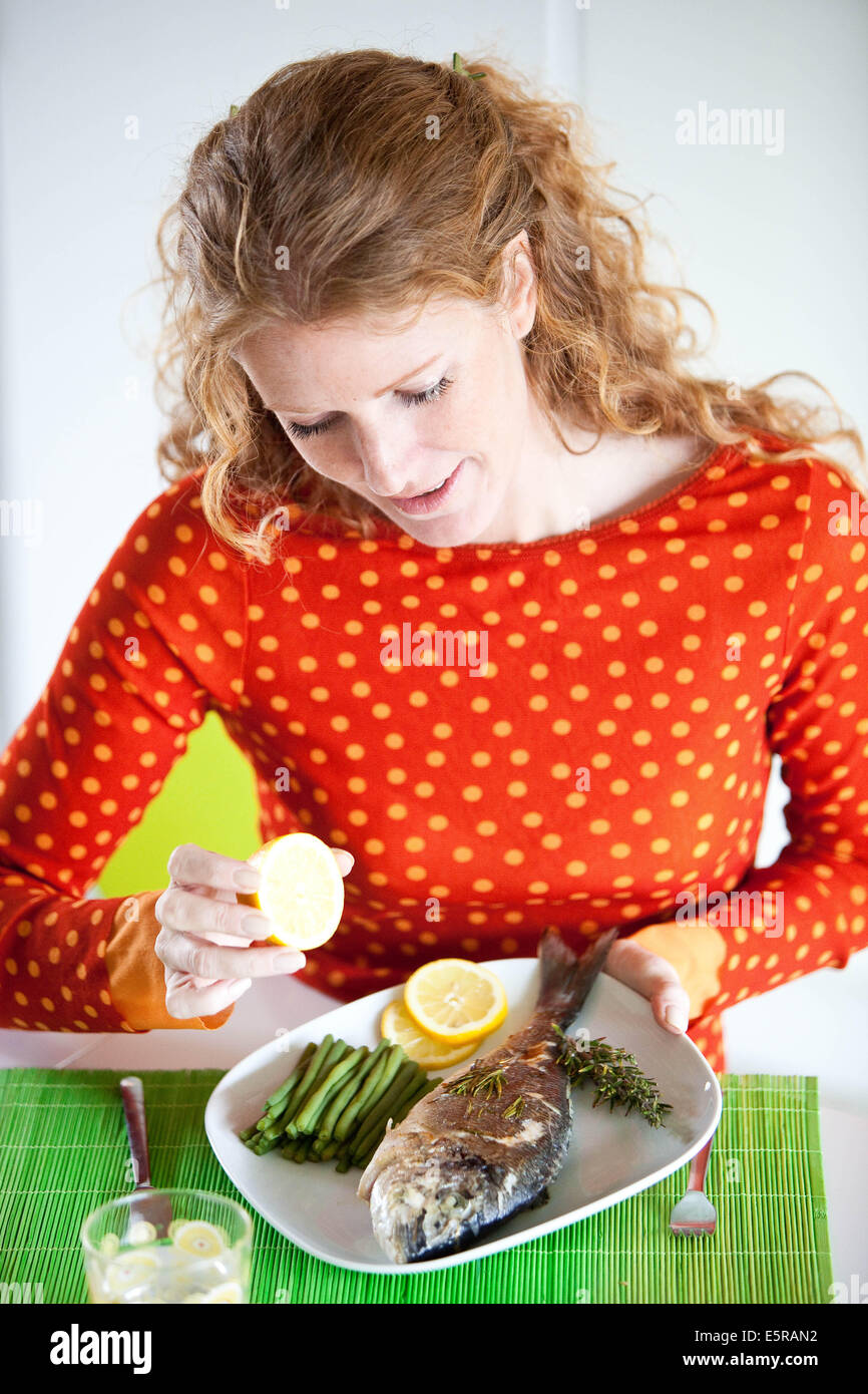 Woman eating fish Stock Photo - Alamy