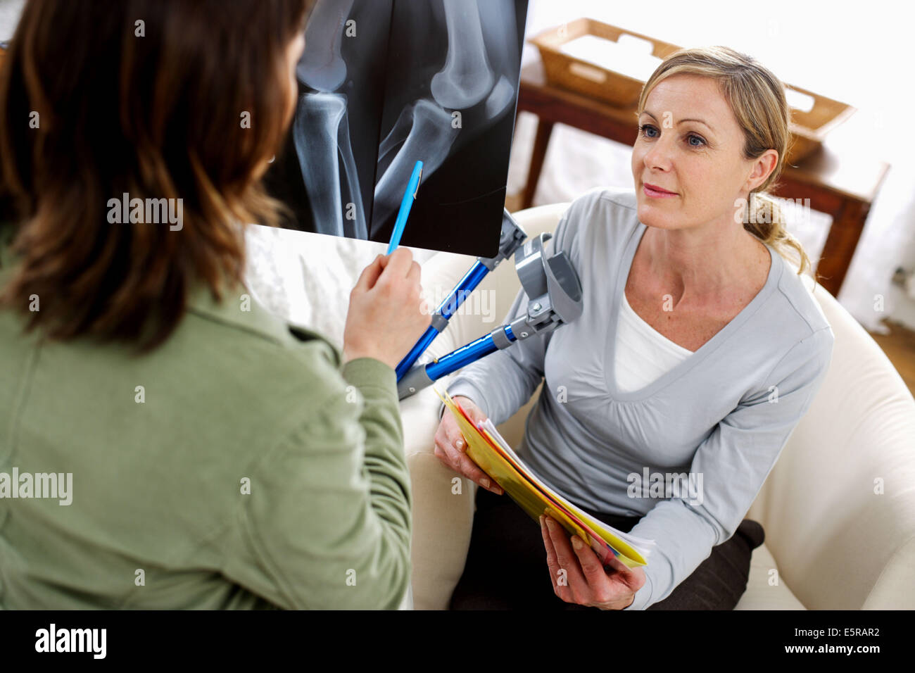 Doctor visiting patient with crutches at home Stock Photo - Alamy