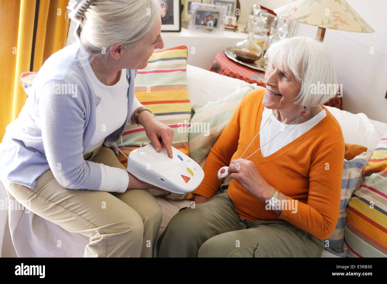 Emergency call button, elderly woman wearing a remote assistance unit ...