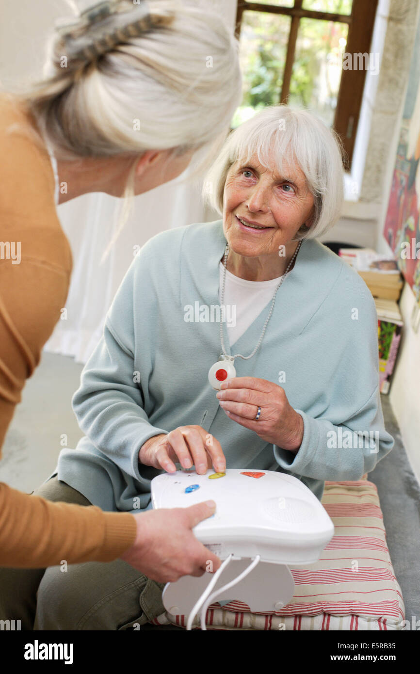 Emergency call button, elderly woman wearing a remote assistance unit ...
