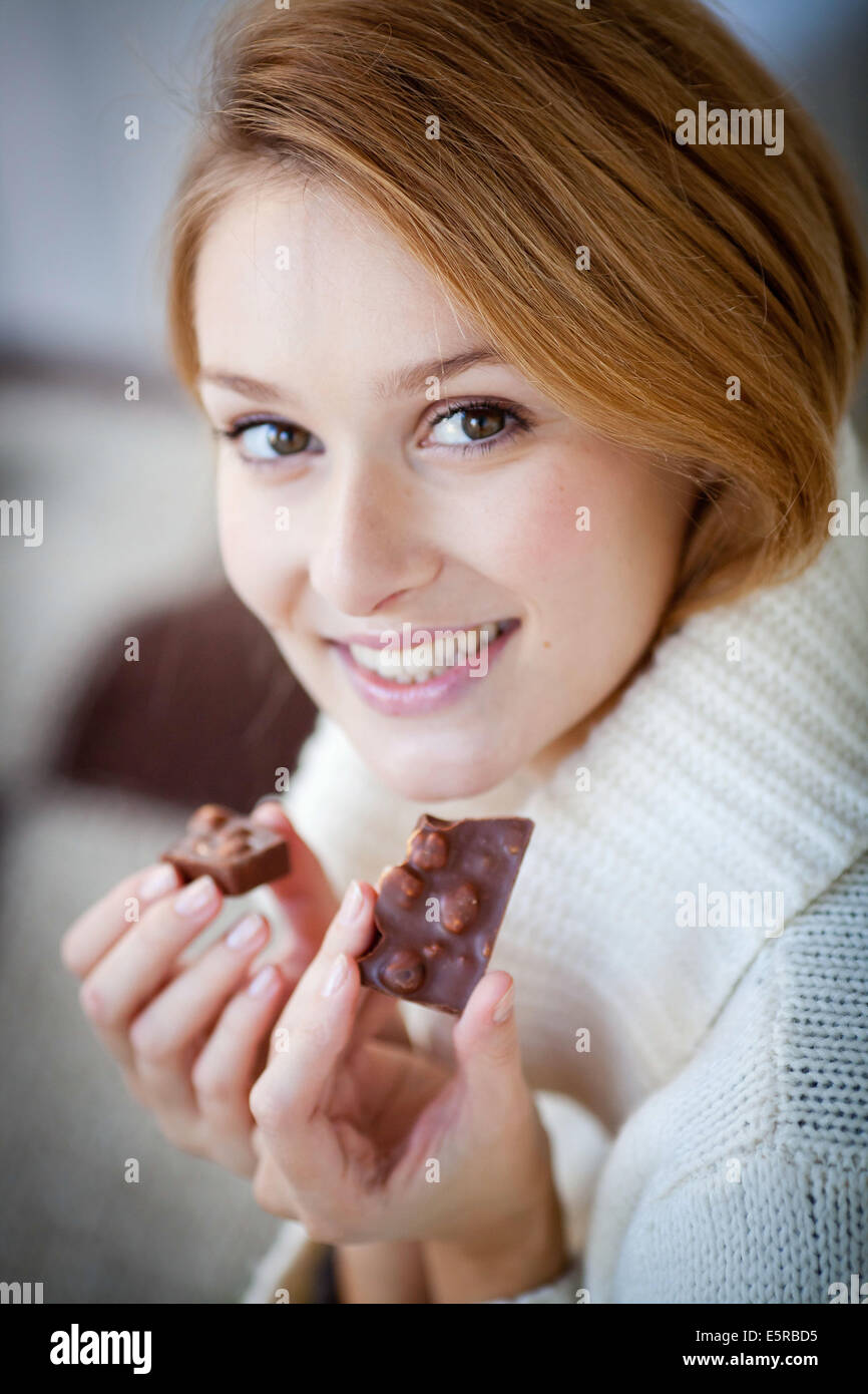 Woman eating hazelnut chocolate Stock Photo - Alamy