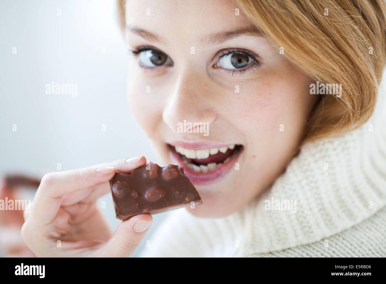Woman eating hazelnut chocolate Stock Photo - Alamy