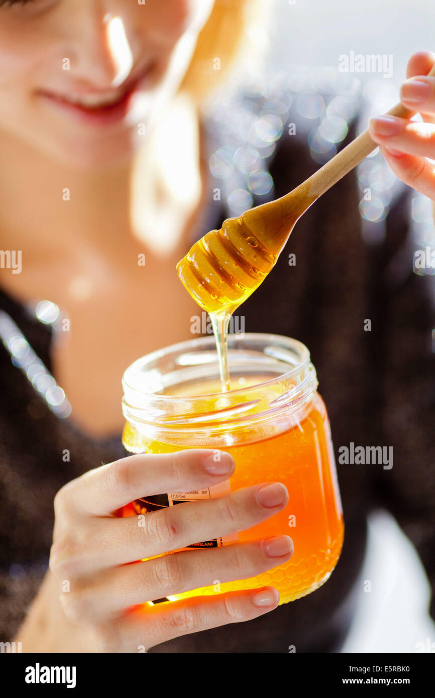 Woman eating honey Stock Photo - Alamy
