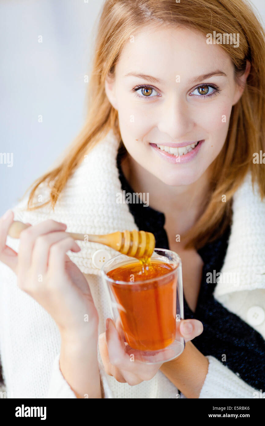 Woman eating honey Stock Photo - Alamy