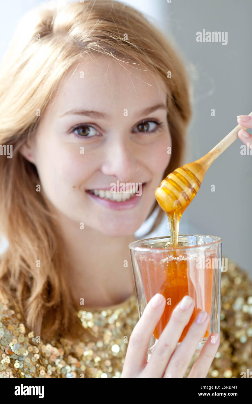 Woman eating honey Stock Photo - Alamy