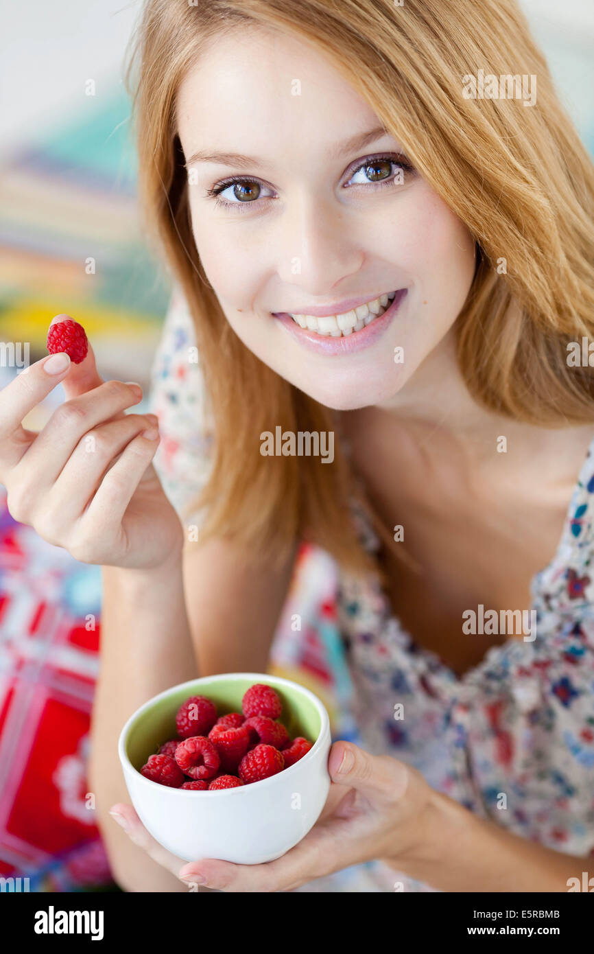 Woman eating raspberries Stock Photo - Alamy