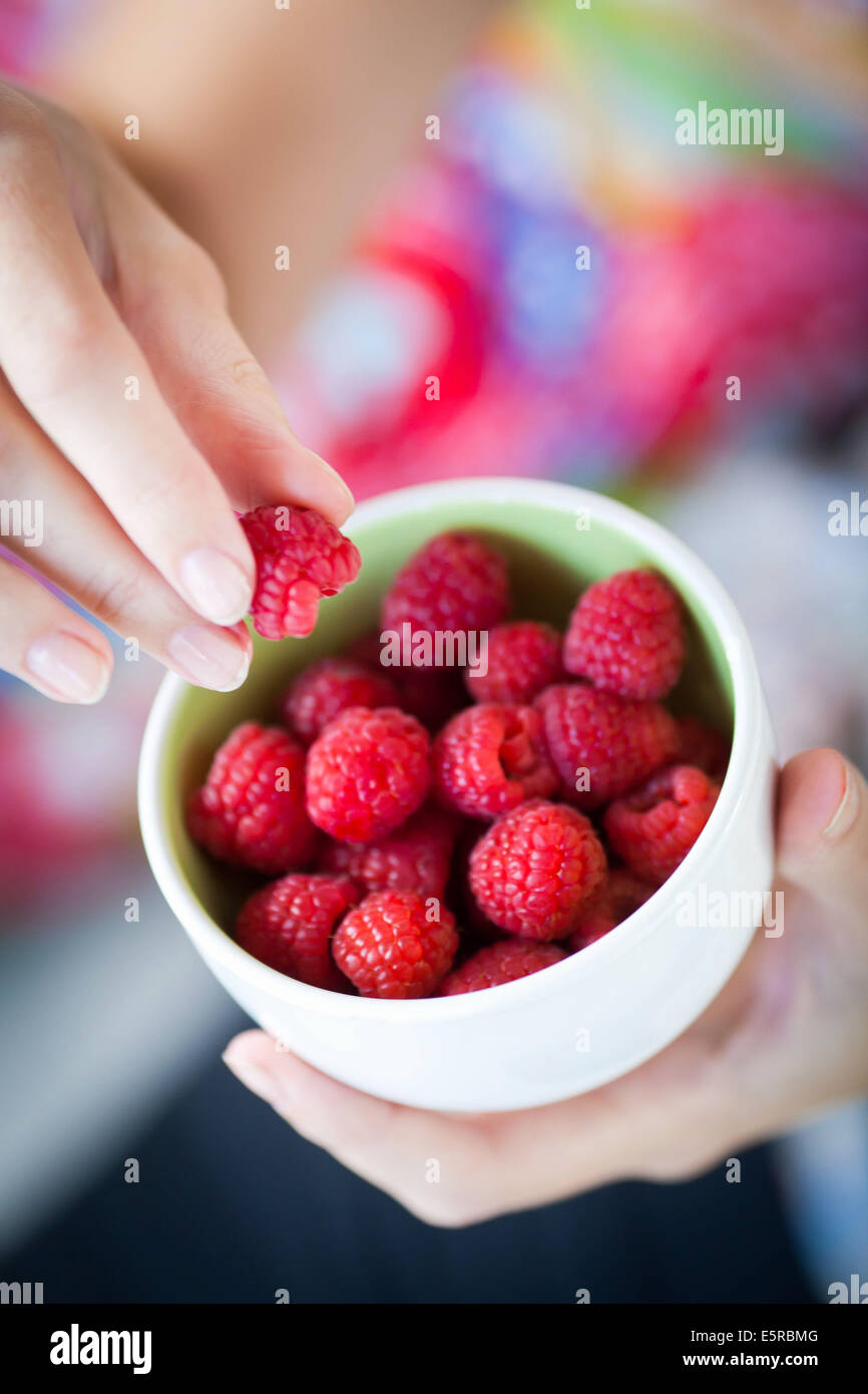 Woman eating raspberries Stock Photo - Alamy