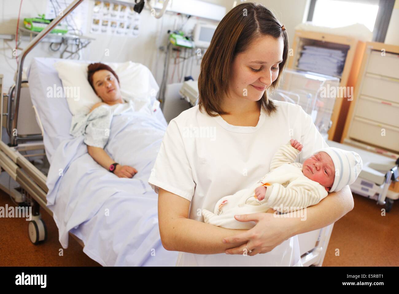Paediatric auxiliary nurse holding a newborn baby, Obstetrics and ...