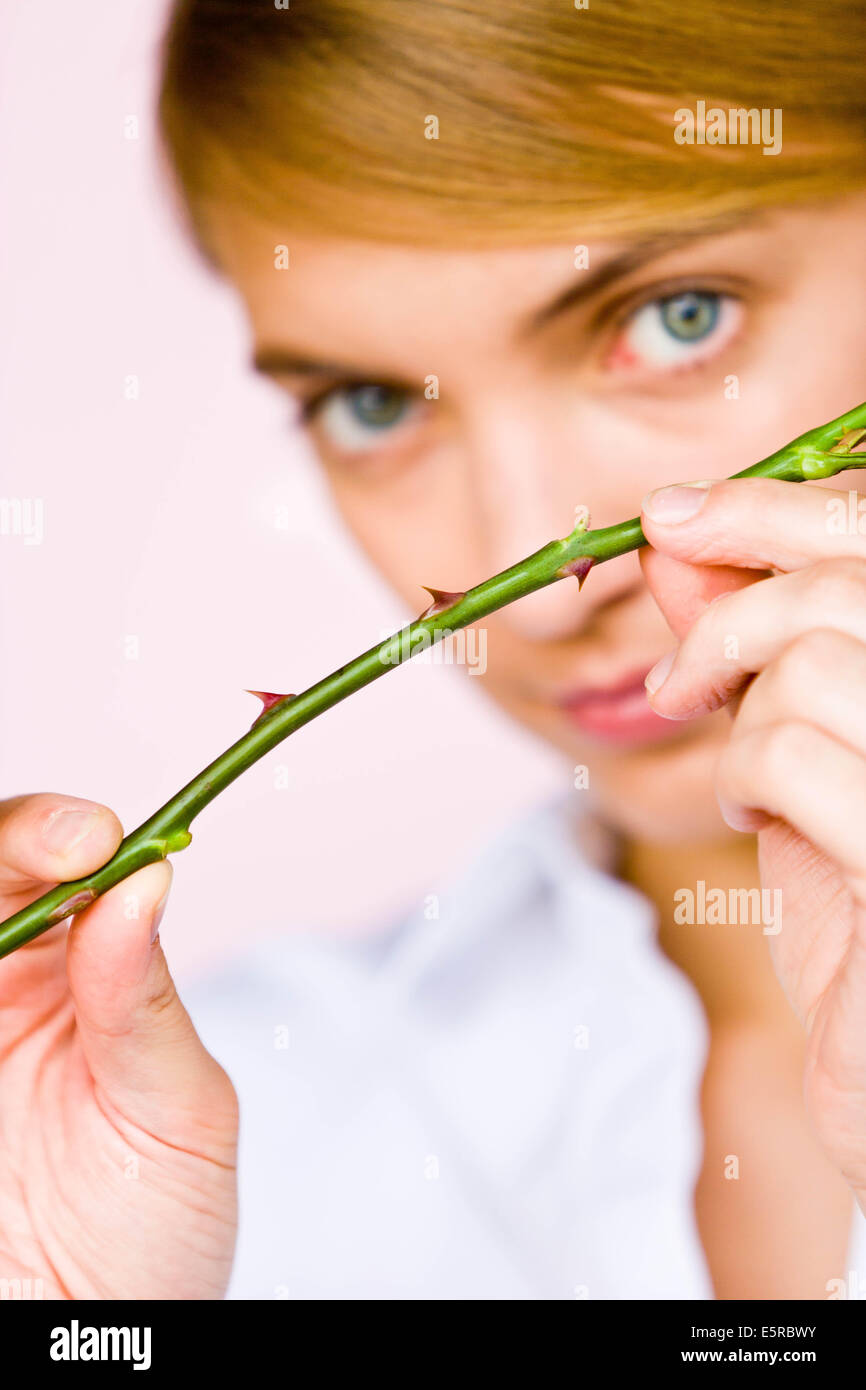 Woman pricking her finger on a rose thorn Stock Photo - Alamy