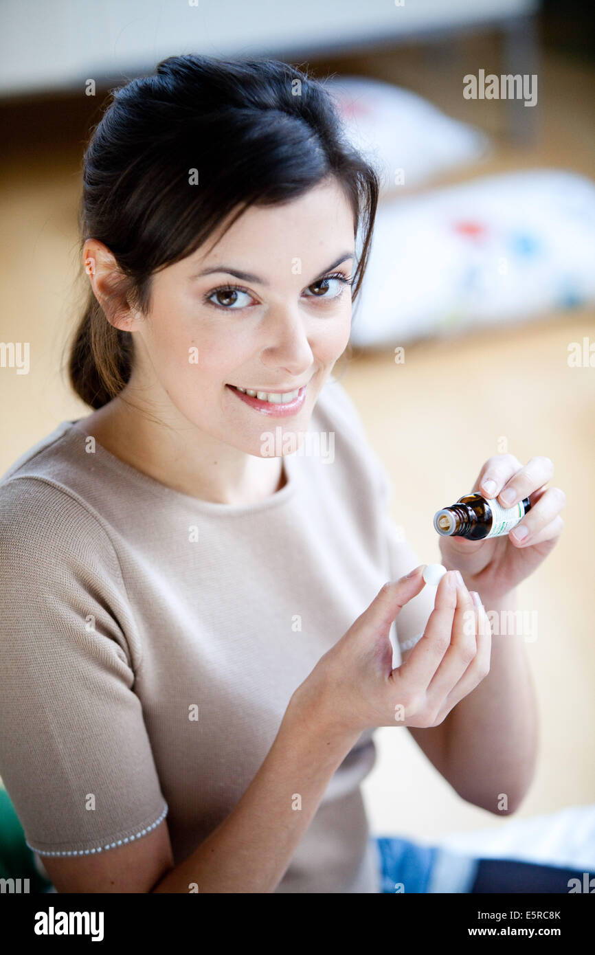 Woman applying essential oil on a neutral pill Stock Photo - Alamy