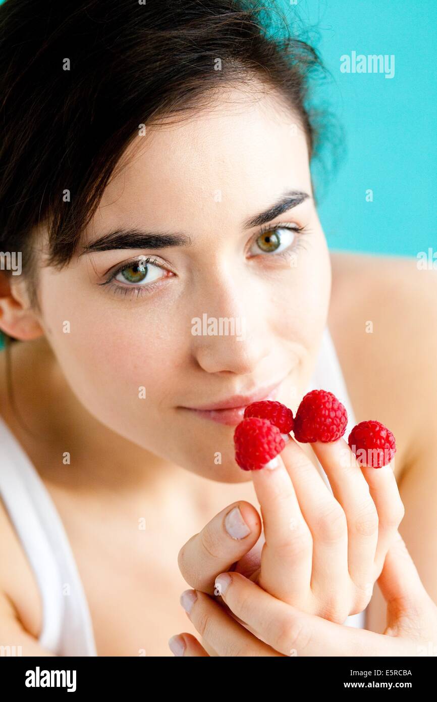 Woman eating raspberries Stock Photo - Alamy