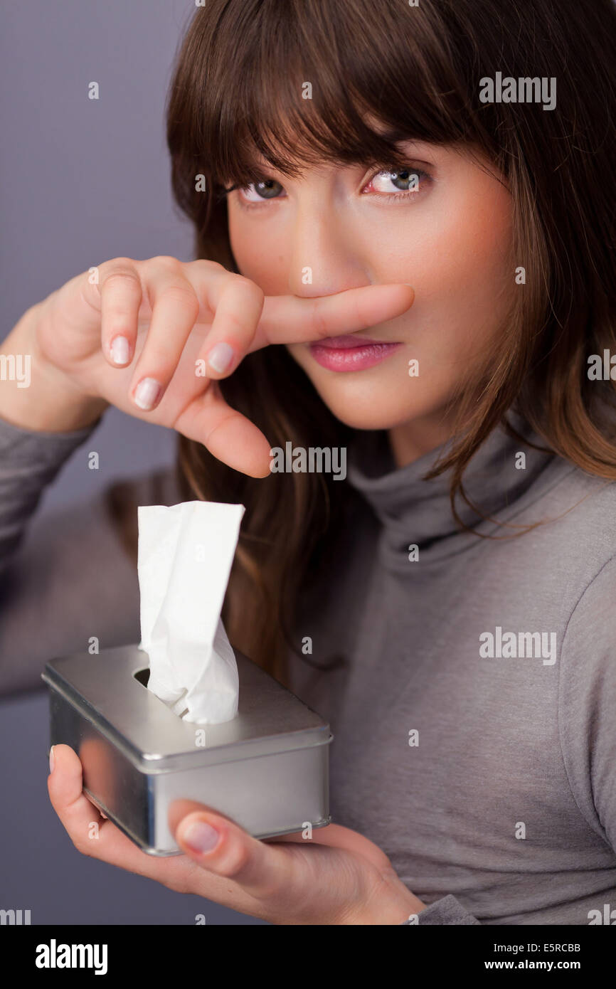 Woman with a cold using tissue Stock Photo - Alamy