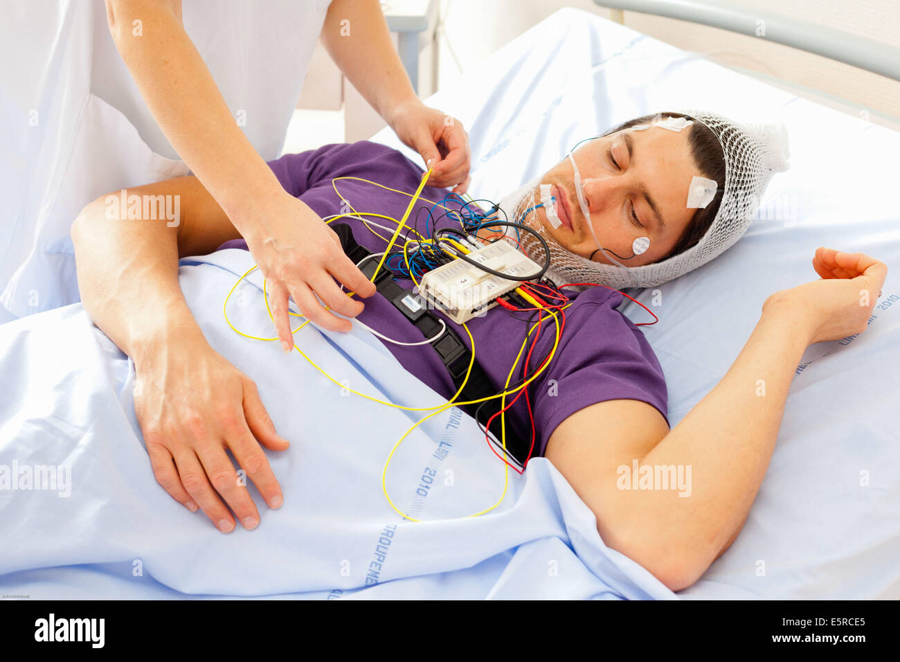 Man undergoing a polysomnographic examination. The polysomnography is ...