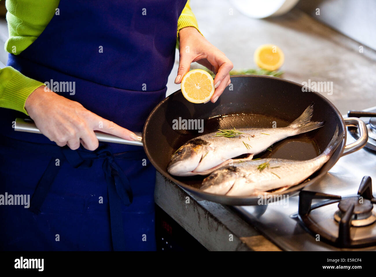 Woman cooking fish Stock Photo - Alamy