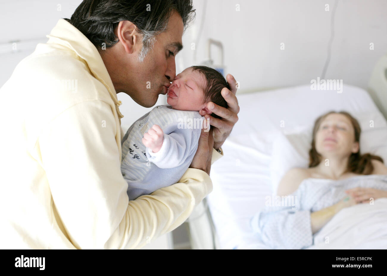 Couple with their newborn baby at maternity, Obstetrics and gynaecology ...