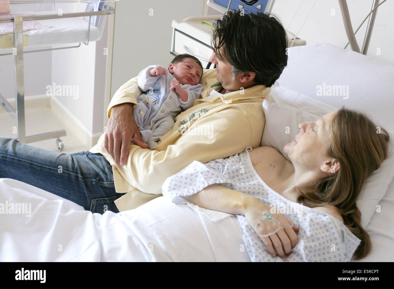 Couple with their newborn baby at maternity, Obstetrics and gynaecology ...