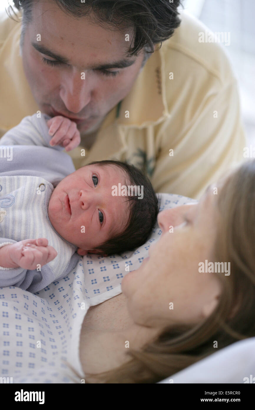 Couple with their newborn baby at maternity, Obstetrics and gynaecology ...