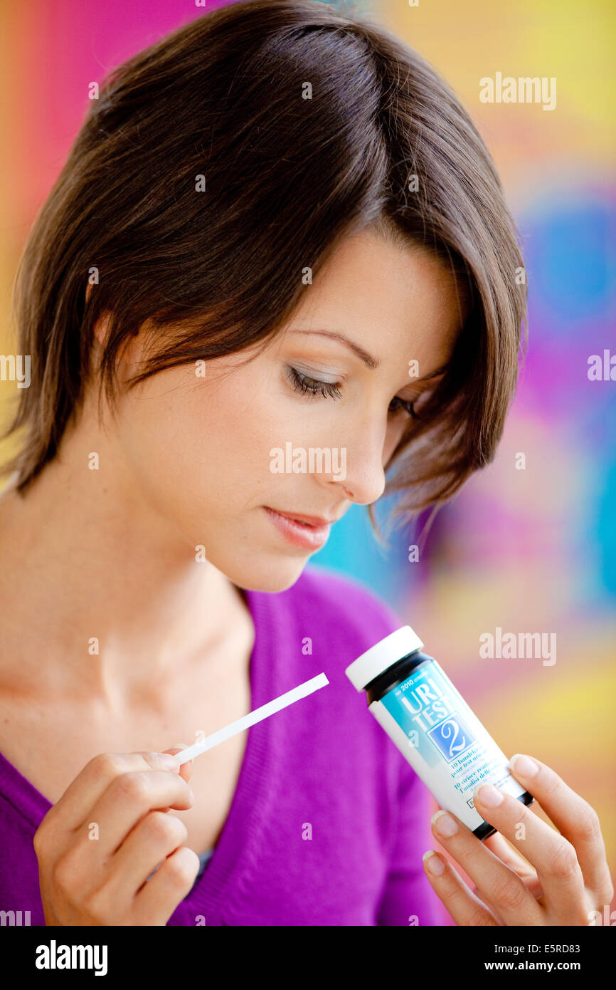 Woman using Uritest urine analysis home test, for urinary tract ...