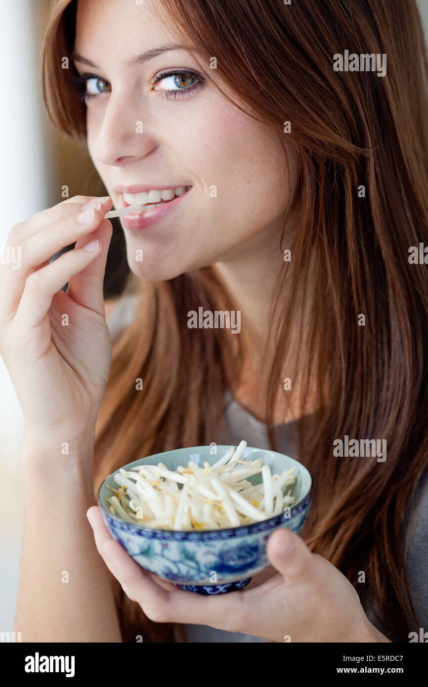 Woman eating soybean sprouts Stock Photo - Alamy