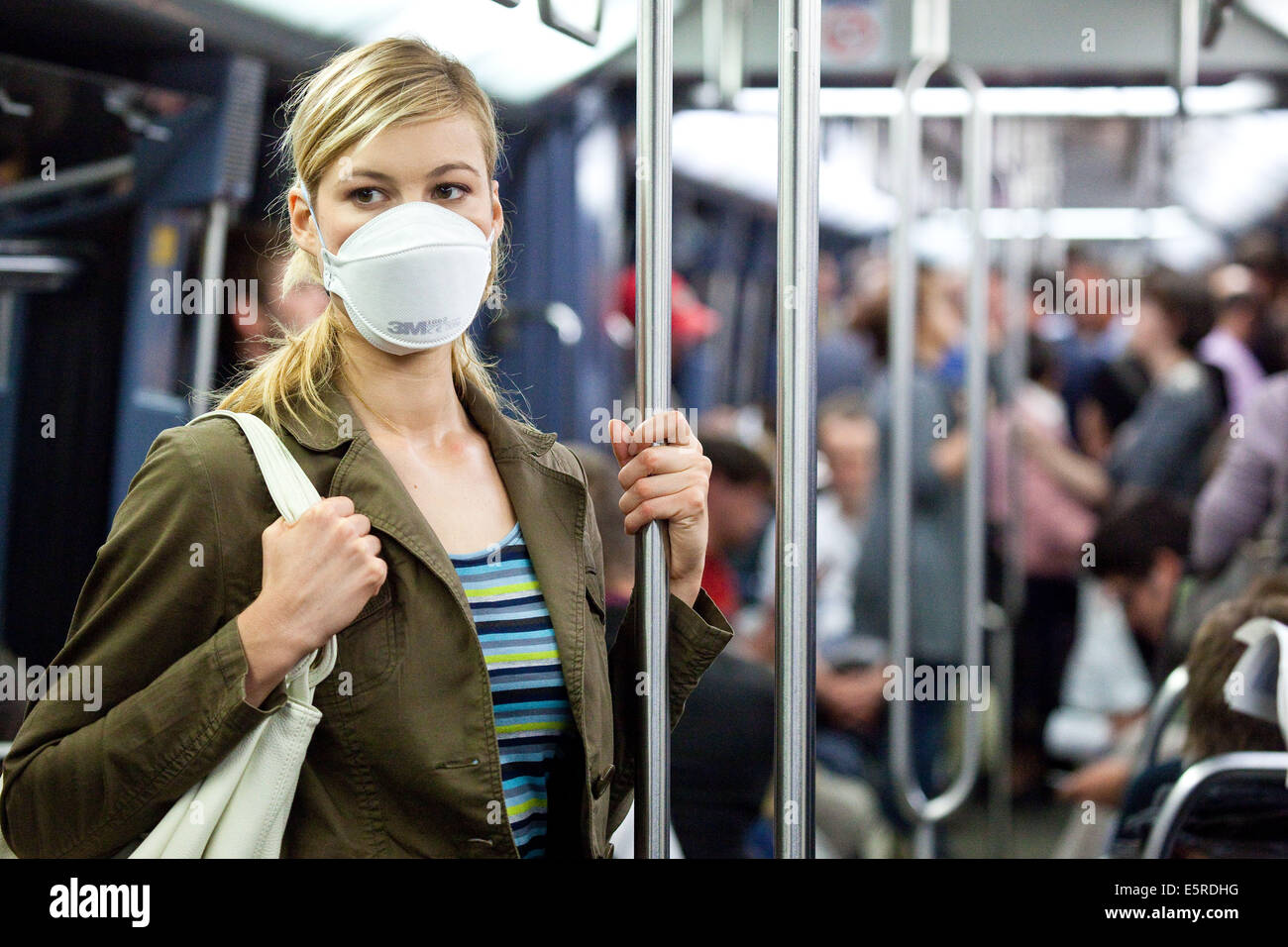 Woman wearing a respiratory protective mask in subway Stock Photo - Alamy