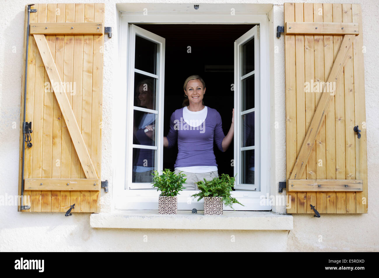 Woman opening window Stock Photo - Alamy