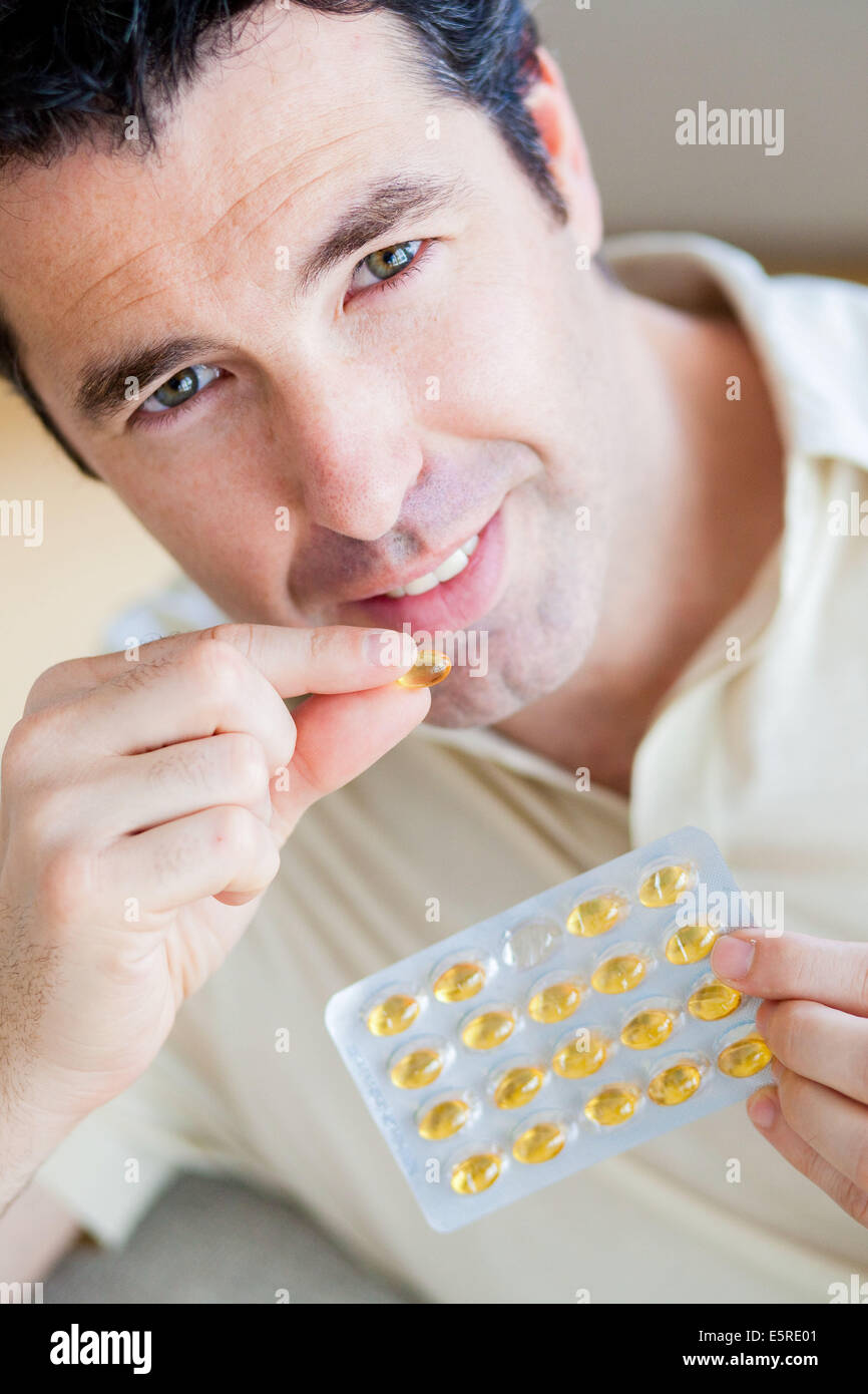 Man taking food supplement capsules Stock Photo - Alamy
