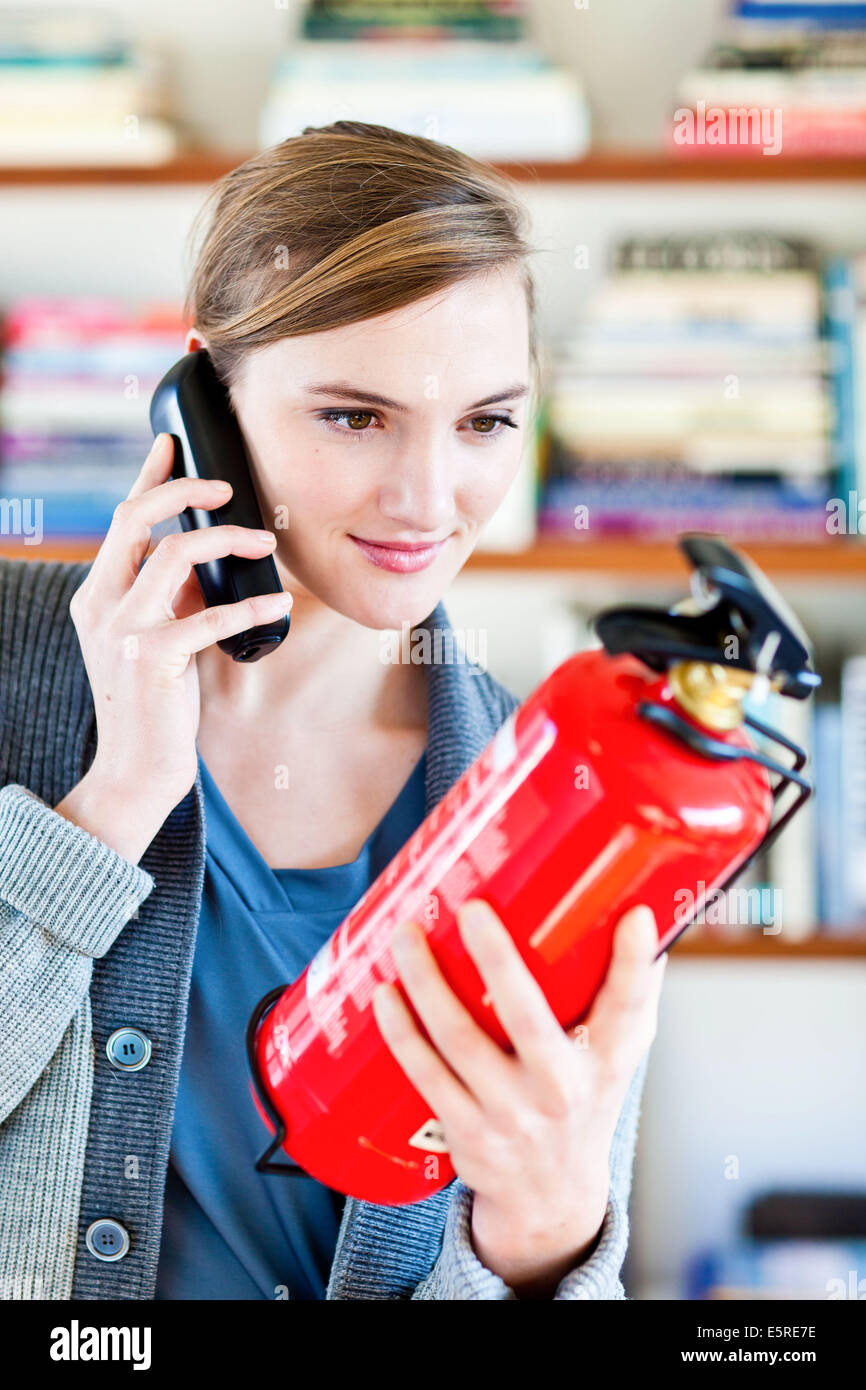 Woman inquiring about using a fire extinguisher Stock Photo - Alamy