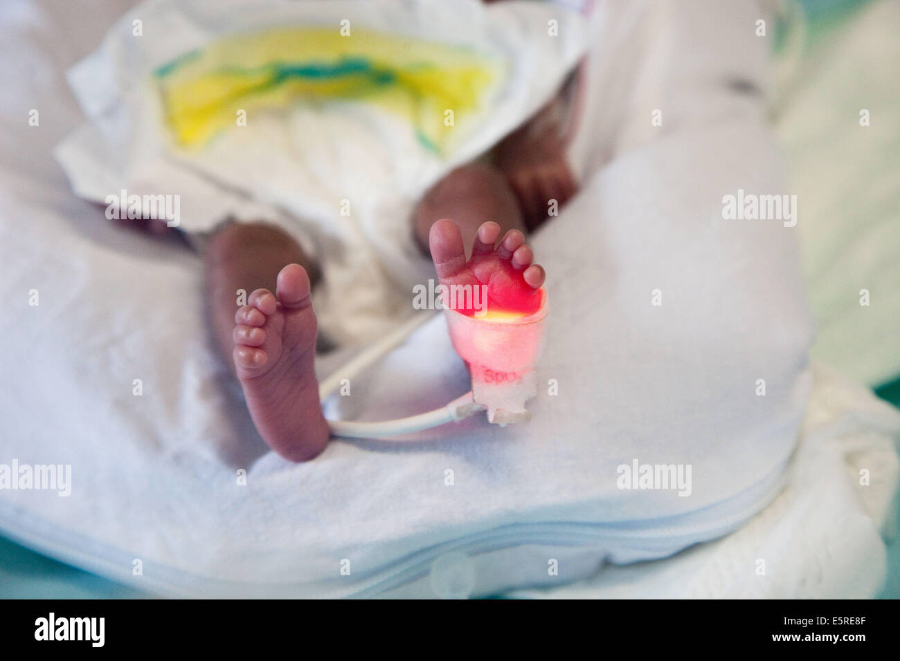 Oxygen meter on the the foot of a premature newborn baby to measure the ...