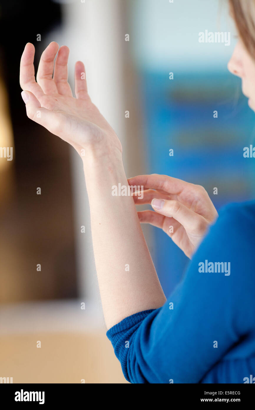 Woman scratching an itch on her wrist Stock Photo - Alamy