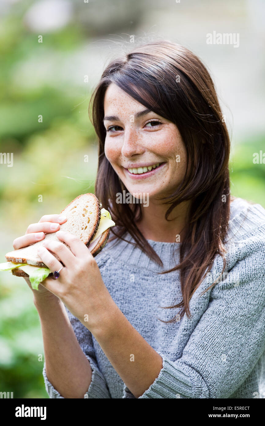 Woman eating sandwich Stock Photo - Alamy