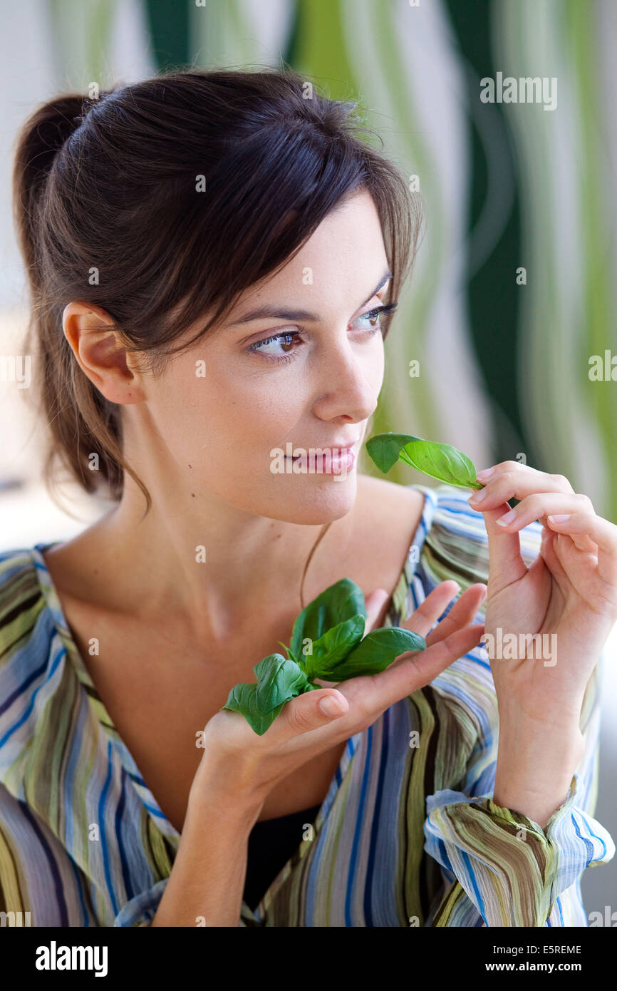 Woman smelling basil Stock Photo - Alamy