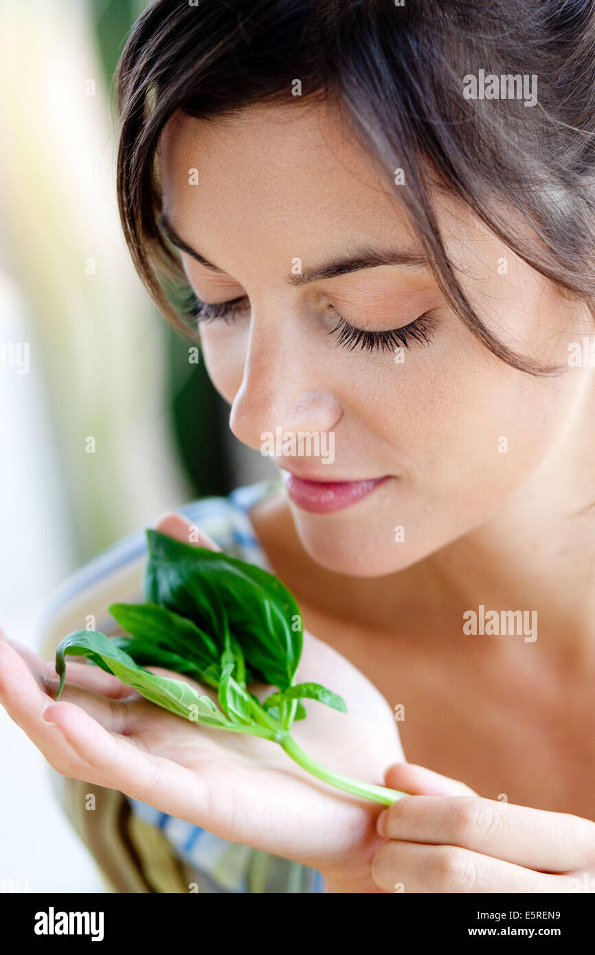 Woman smelling basil Stock Photo - Alamy