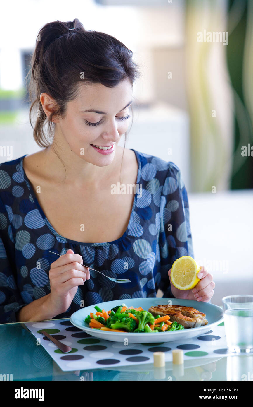 Woman eating fish Stock Photo - Alamy